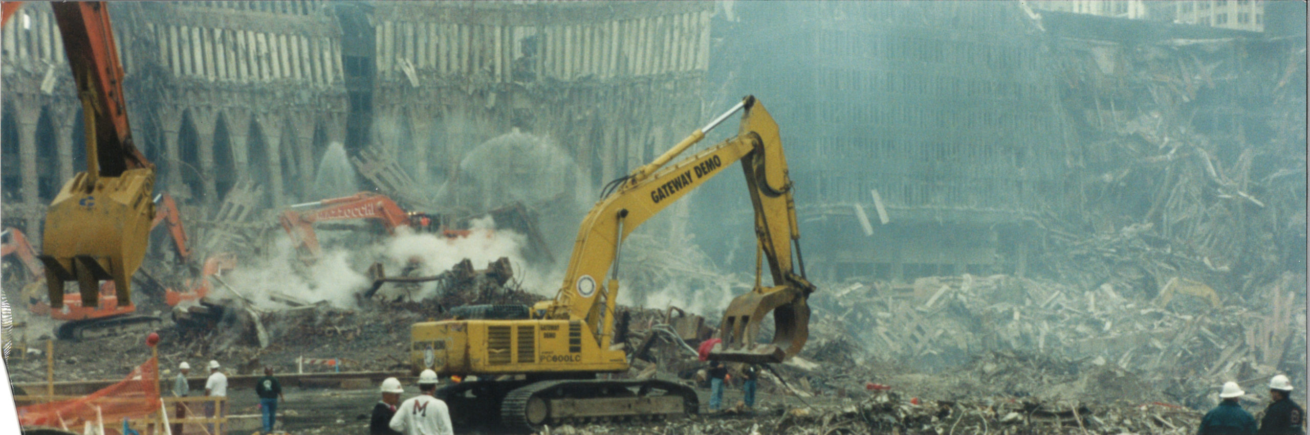 Diggers Working at Ground Zero with Workers, Debris, and Smoke Visible ...