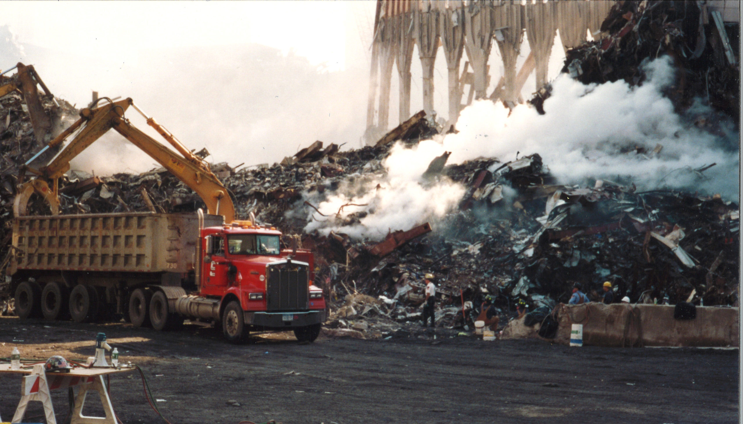 Crane Moving Debris into a Skip with Smoke Pouring Over Debris at ...