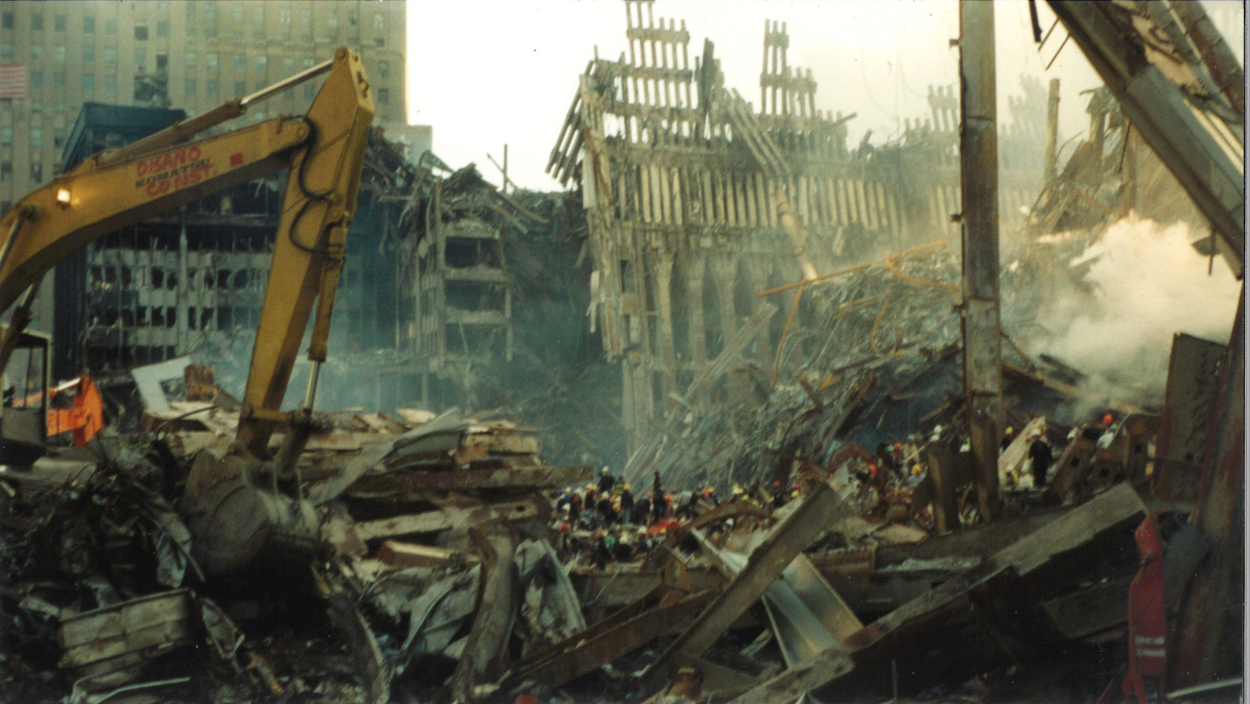 Cranes Working Through Building Rubble with many Hard Hats Visible ...