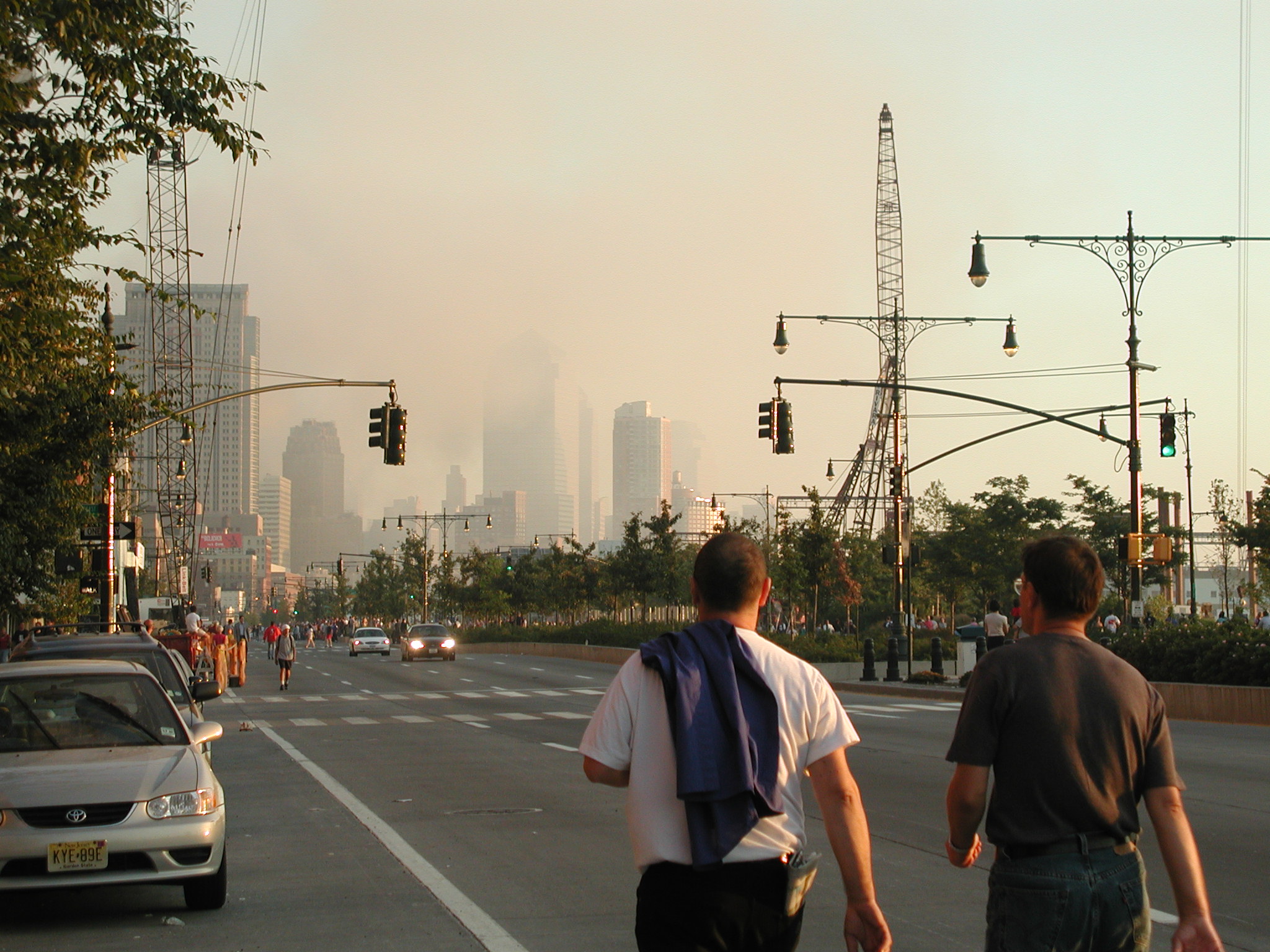 People walk down West Street as smoke from September 11th attacks ...